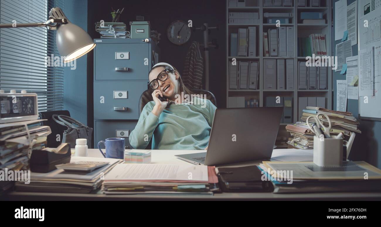 Lazy office worker sitting at desk and talking on the phone with her ...