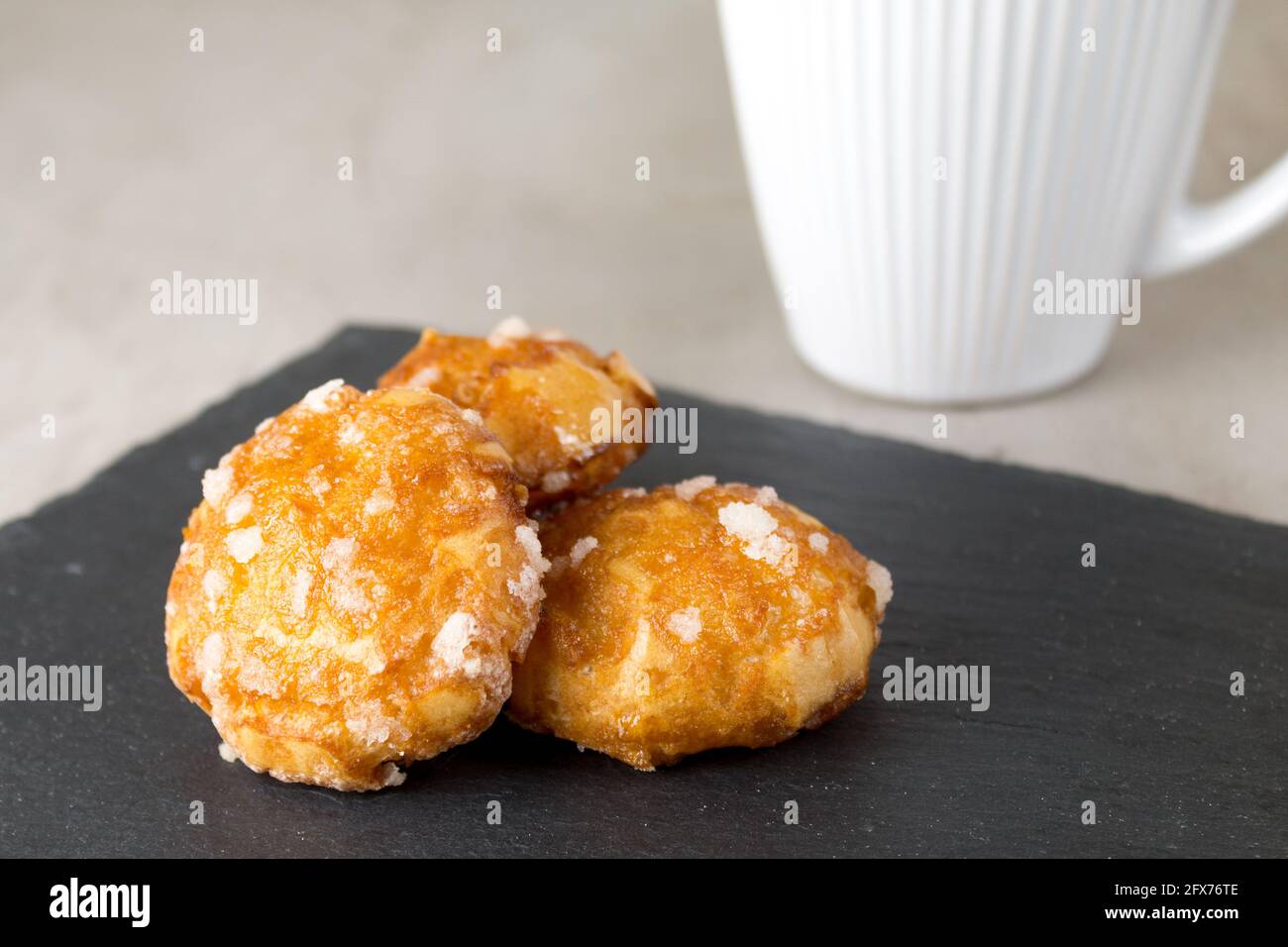 french chouquettes puffs with perles of sugar on black slate board with ...