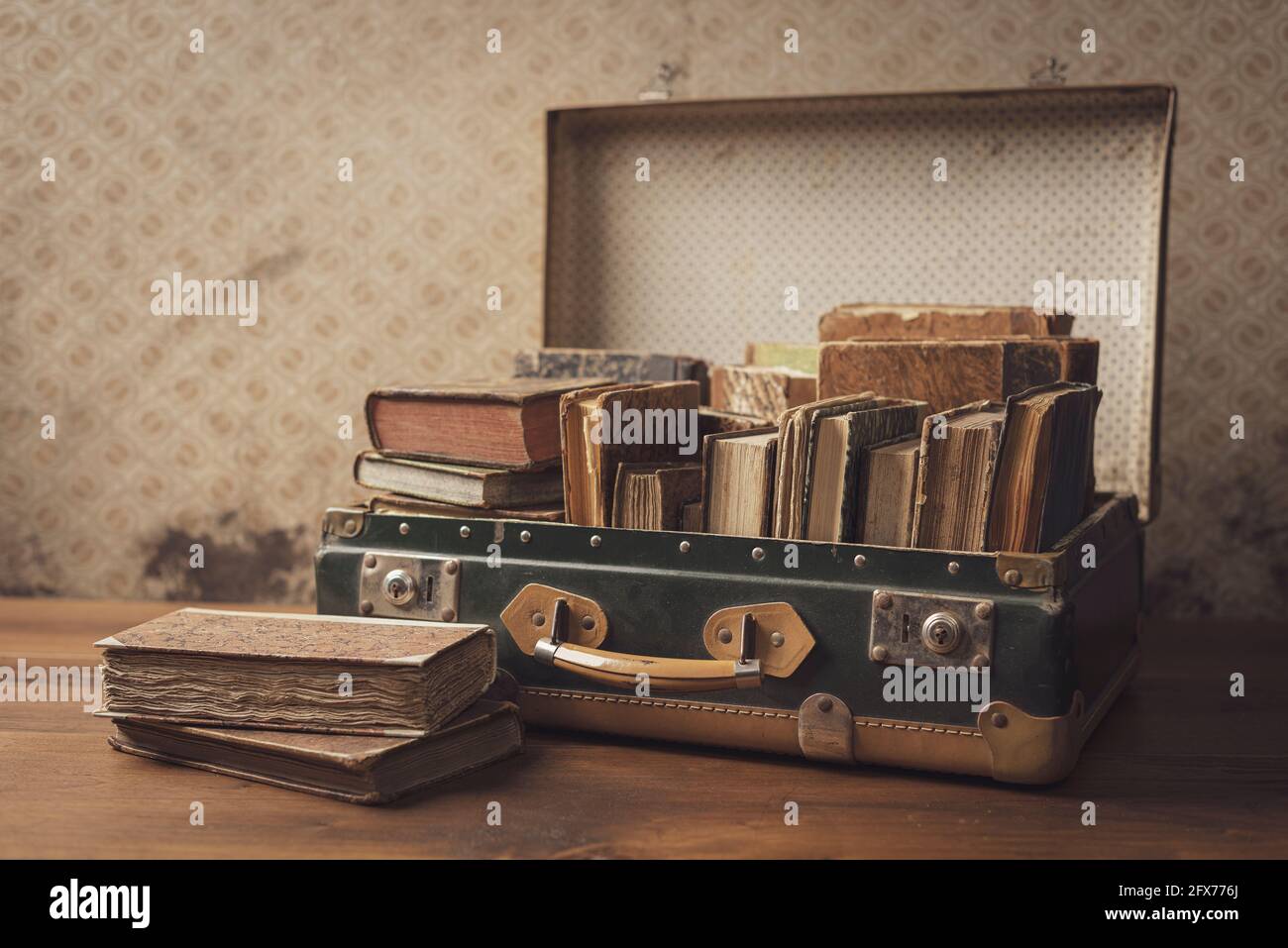 Old leather suitcase with books on the floor. Suitcase in retro style ...