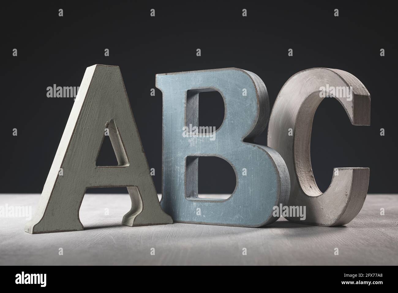 ABC alphabet wooden letters standing on a table on dark background ...