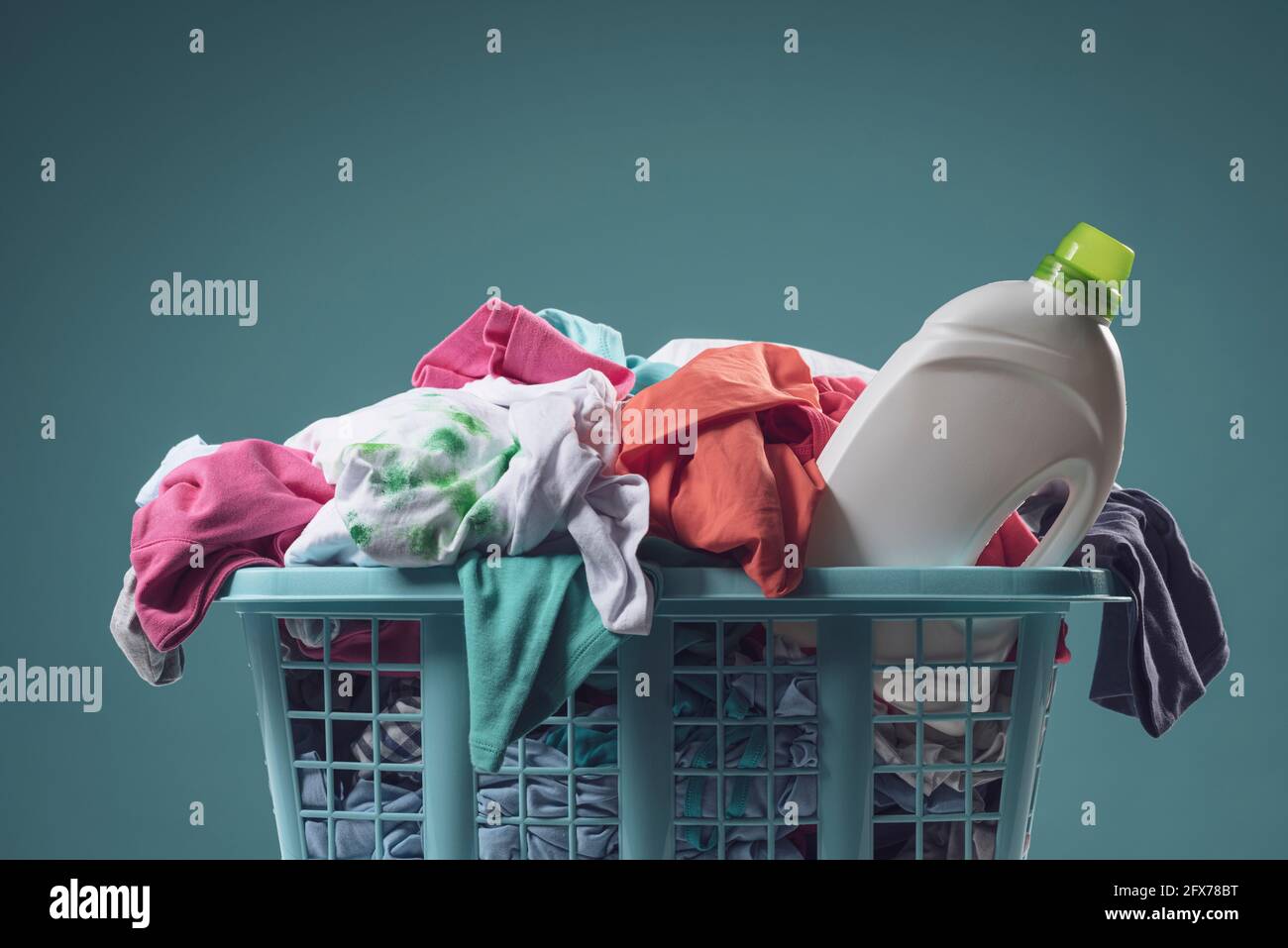 Green detergent and clothes in a laundry basket: eco-friendly laundry ...