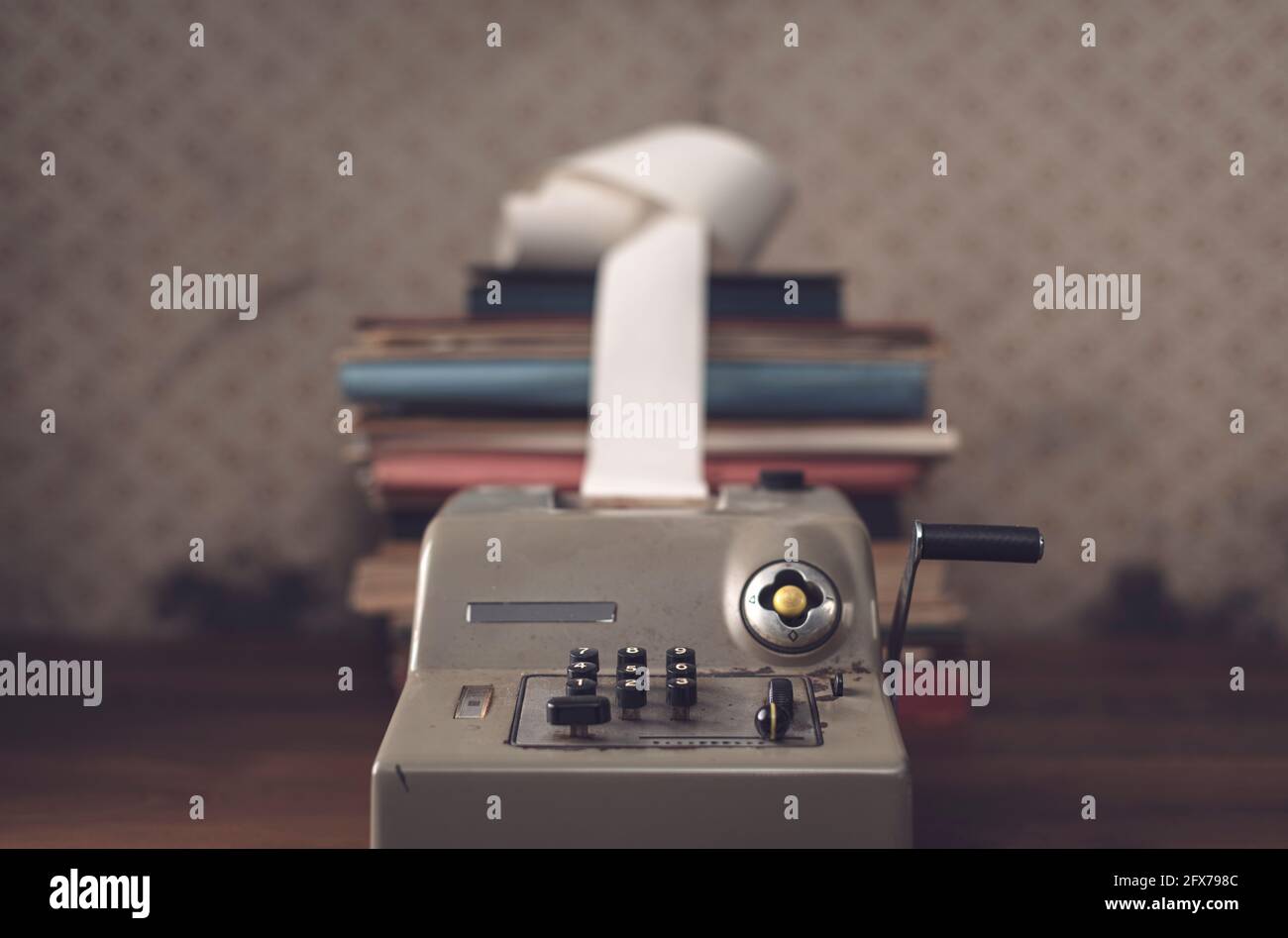 Vintage calculator with handle and paper roll on the accountant desk ...