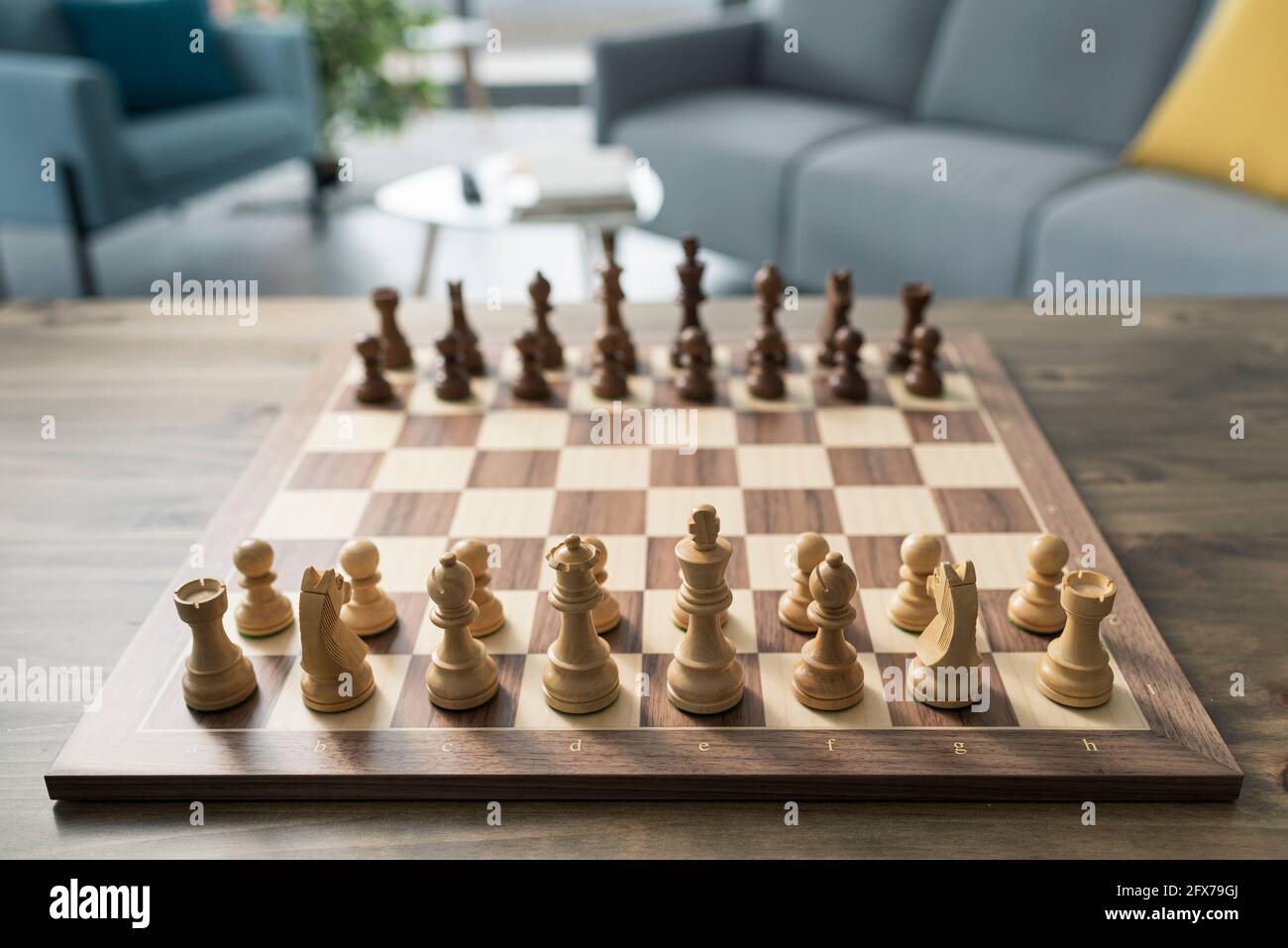 Chessboard ready for the game on the table and living room interior in ...