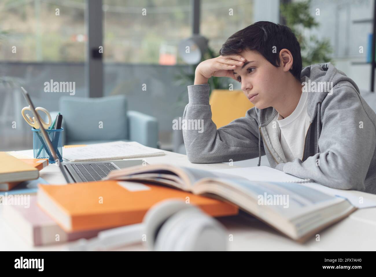 Tired student taking online classes, he is confused and staring at the ...