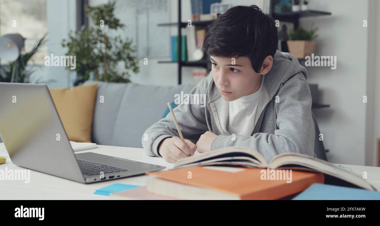 Smart student sitting at desk and taking classes online, distance ...
