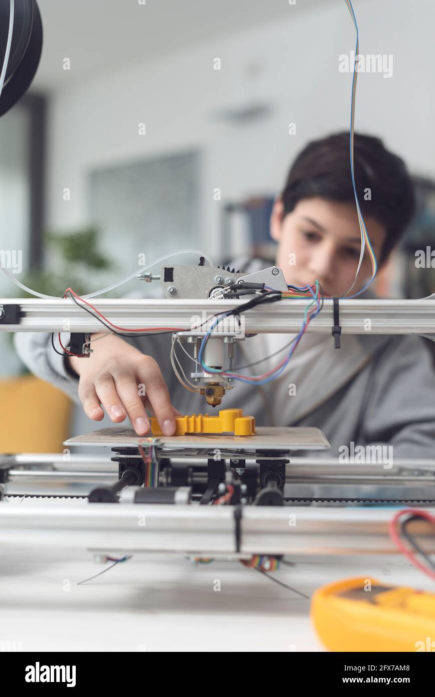 Smart boy printing a prototype using a 3D printer, science and ...