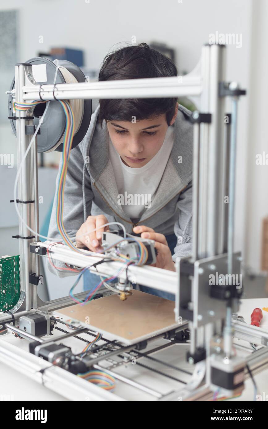 Young smart student using a 3D printer in the lab, engineering and ...