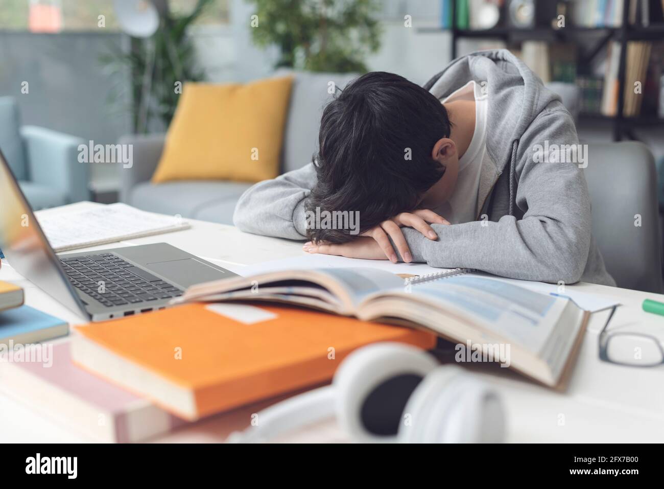 Tired student falling asleep over the desk, he is sad and exhausted ...
