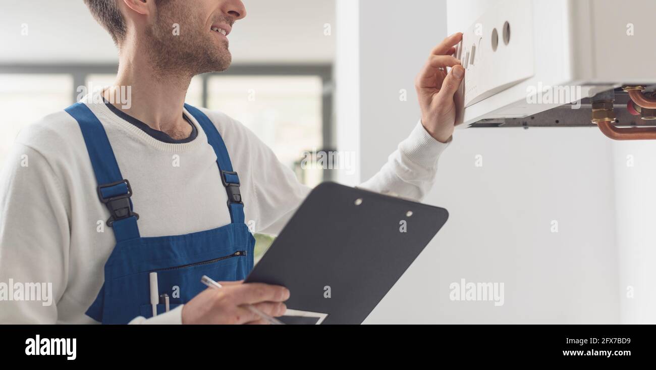 Professional plumber checking a boiler control panel, he is adjusting a ...