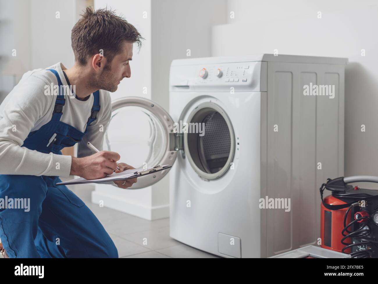 Plumber servicing domestic washing machine hi-res stock photography and ...