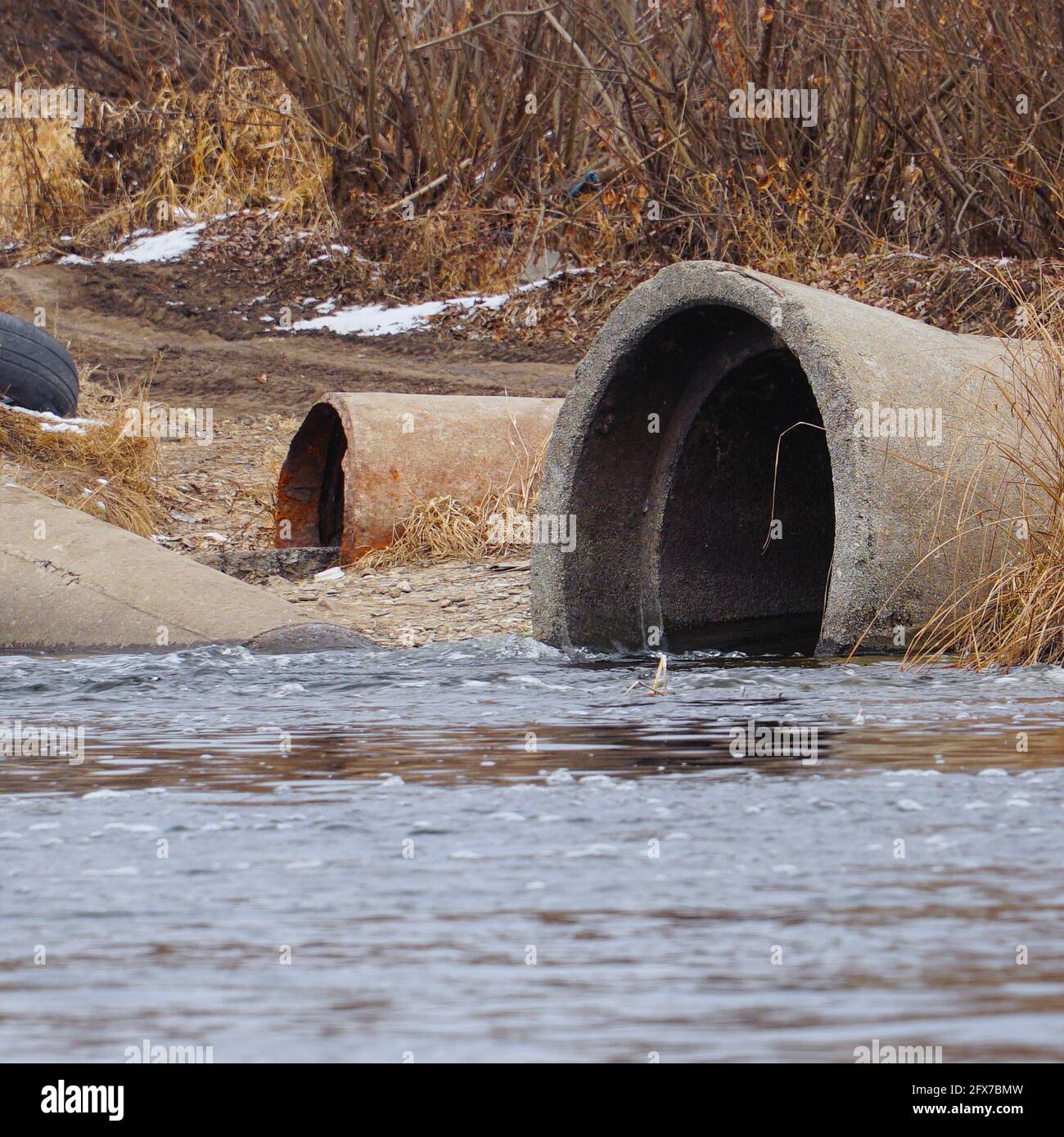 The water on the river flows from large pipes. Dam on the river Stock ...