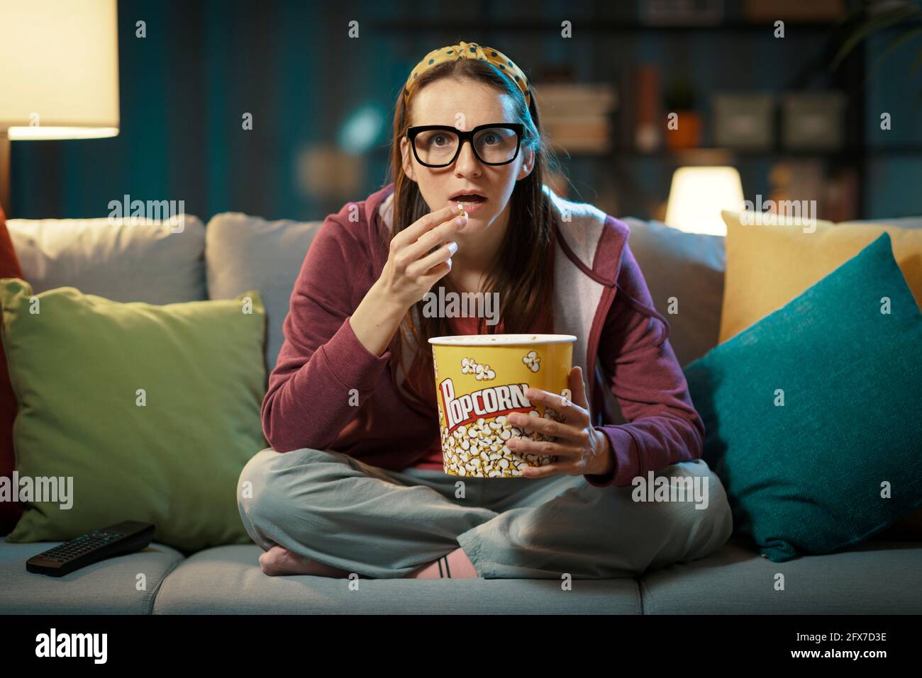 Woman watching a suspense movie and eating popcorn Stock Photo - Alamy