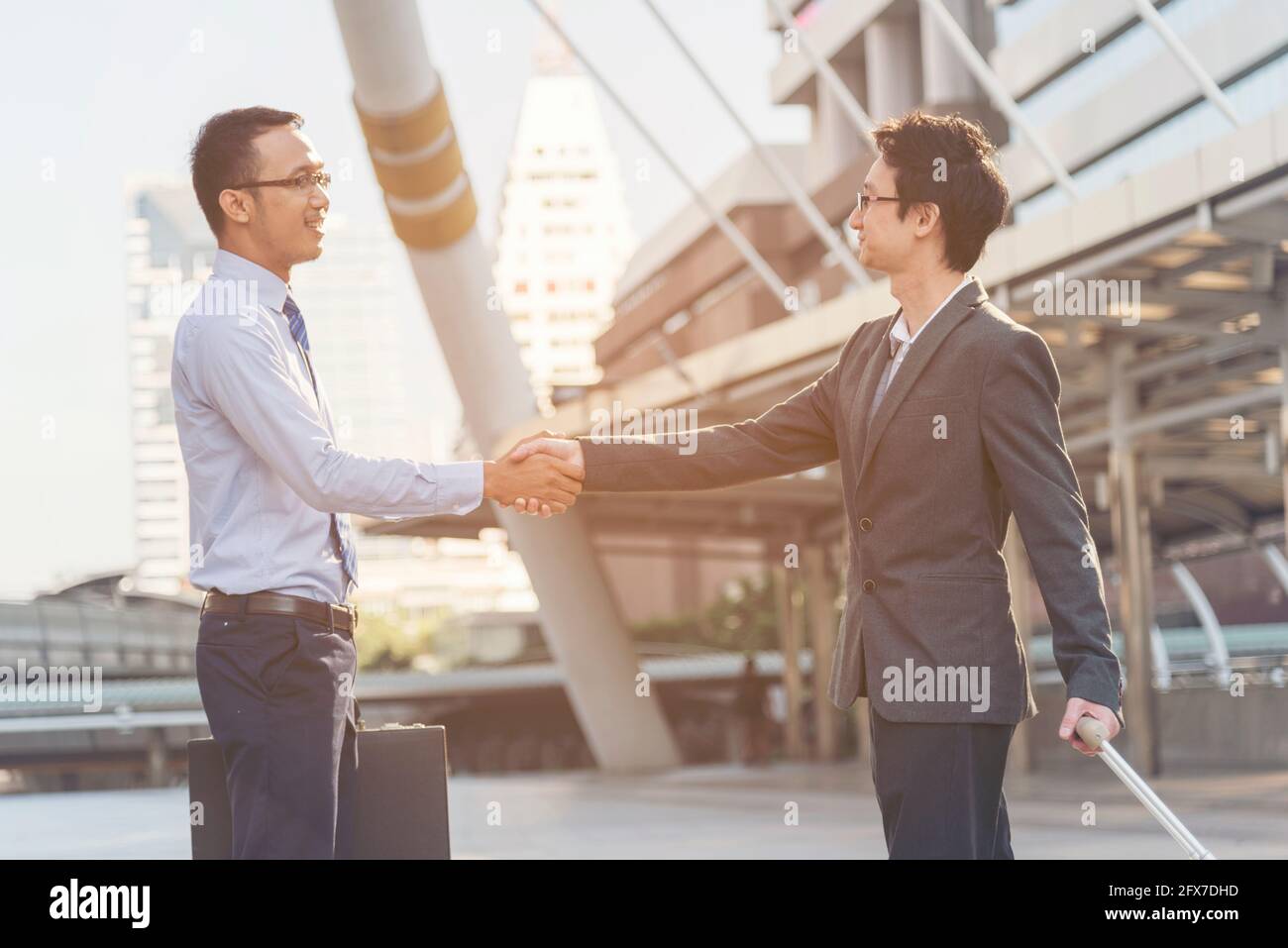 Business partners meet up outside the office. city view is a background ...