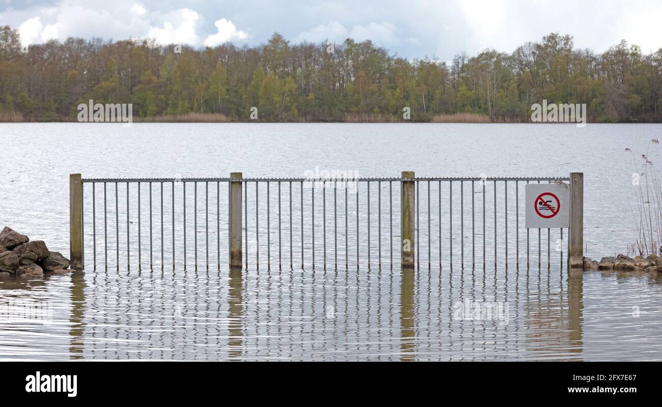 Metal large fence in the water, forbidden to swim Stock Photo - Alamy