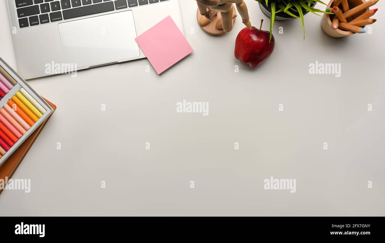 Designer workspace with paint tools, laptop, apple and copy space, top ...