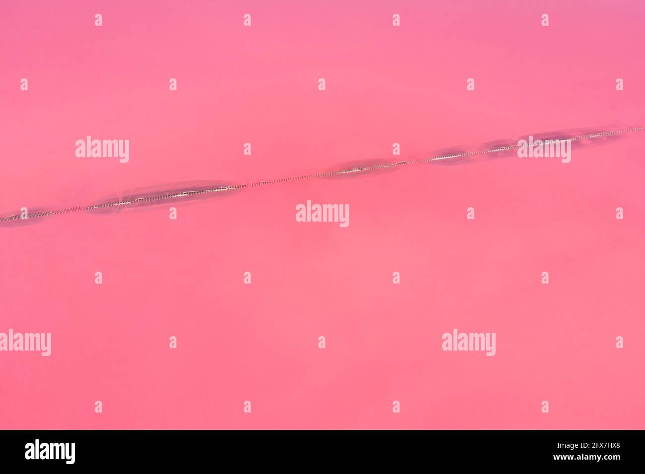 Aerial view of wooden structures for collecting salt on a pink lake ...