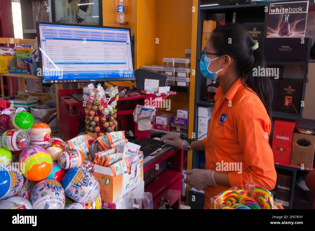 during an outbreak of COVID - 19, a supermarket cashier wears a ...