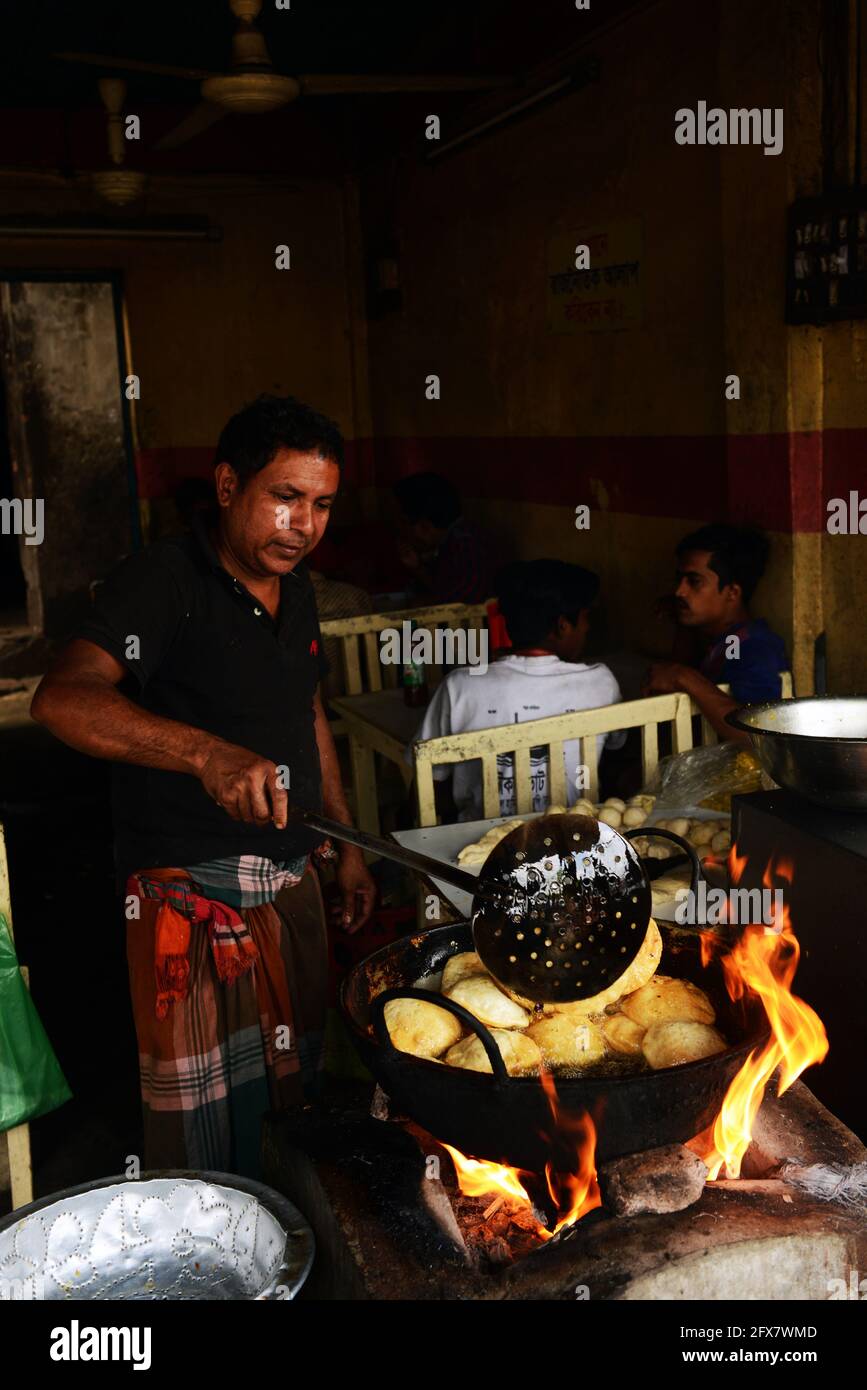 A Bangladeshi man deep frying puri bread in Dhaka, Bangladesh Stock ...
