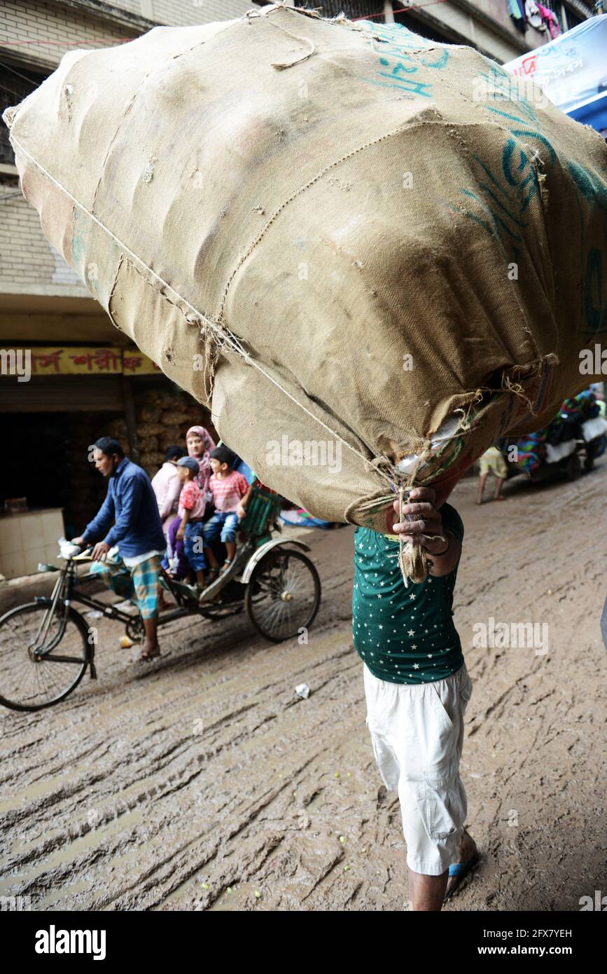 A Bangladeshi man carrying a huge sack on his head. Chawk Bazar, Dhaka ...