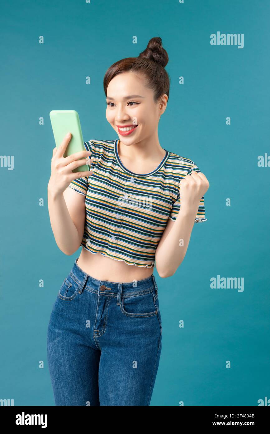 happy joyful girl holding mobile phone and celebrating a win Stock ...