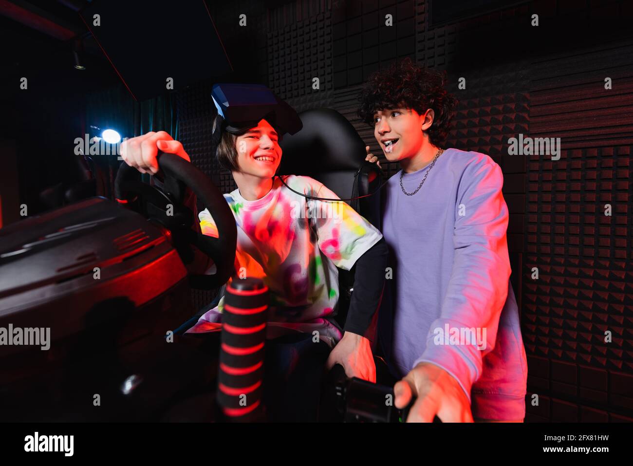 excited boy talking to friend in car racing simulator Stock Photo - Alamy