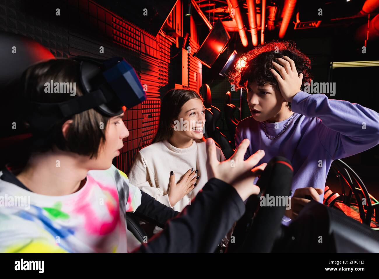 emotional gamers talking and gesturing near car racing simulator Stock ...