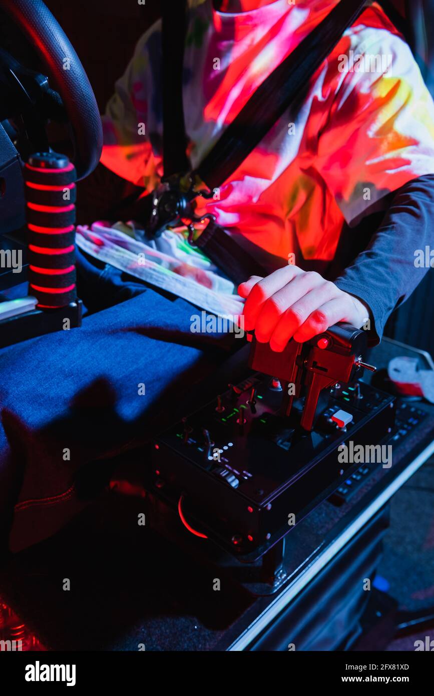 cropped view of teenage guy operating gear box while gaming on car ...