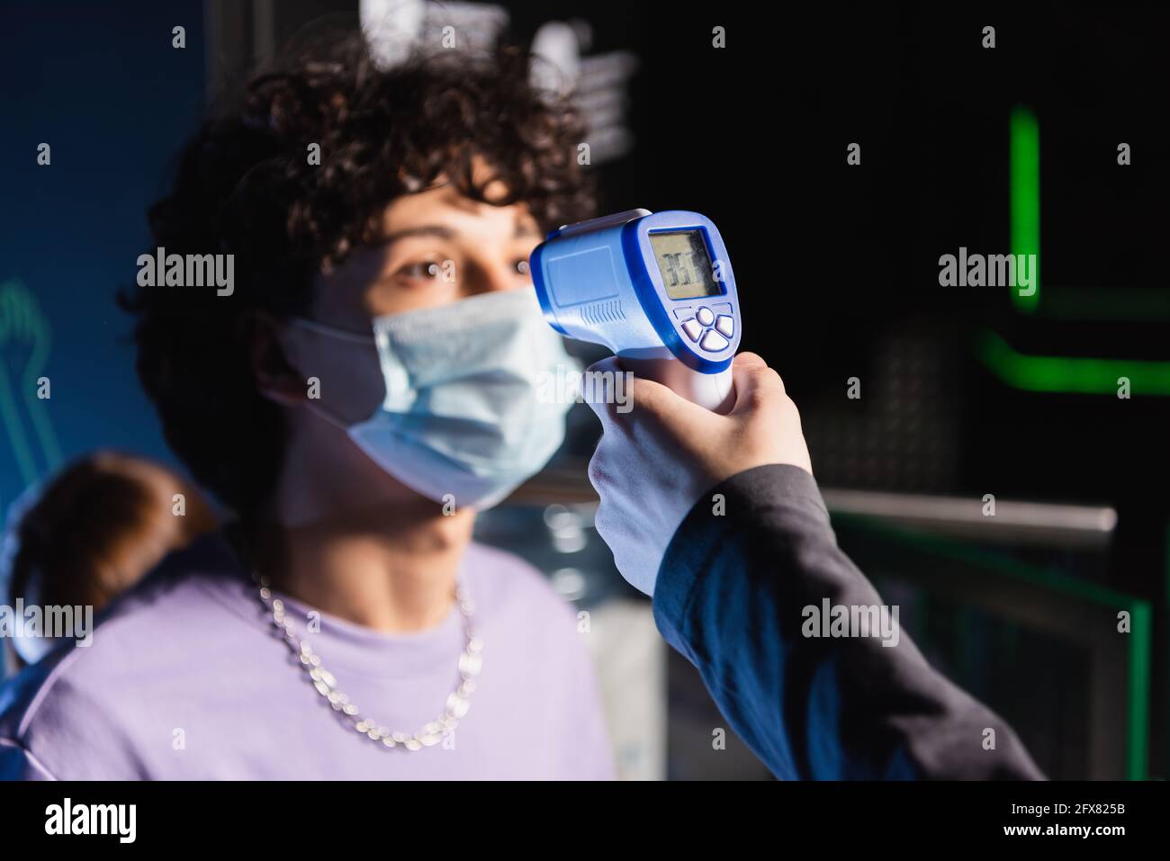 selective focus of pyrometer in hand of controller near boy in safety ...