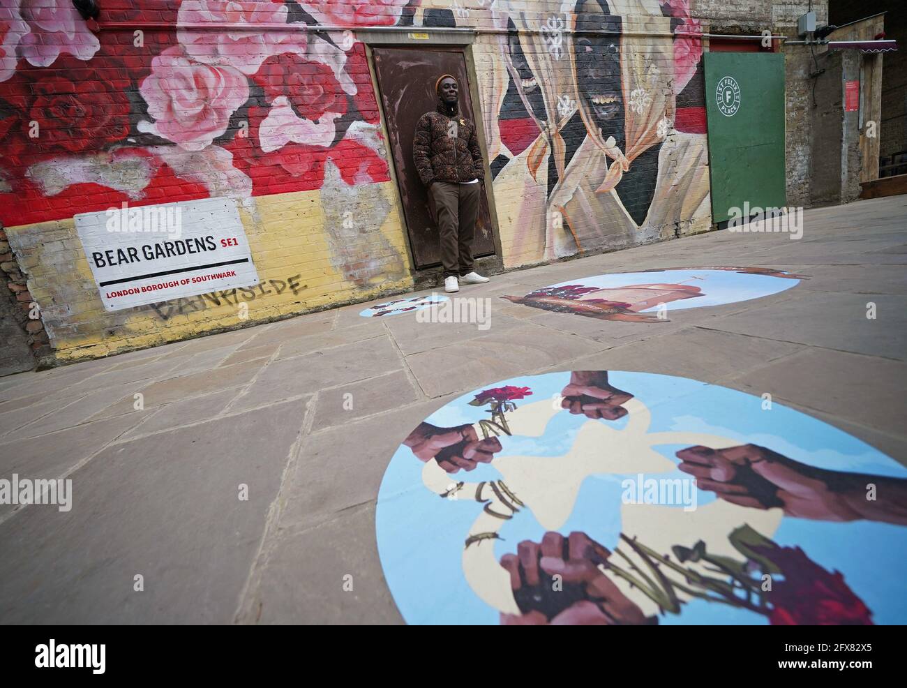 Koby Martin poses next to his works (on wall) Spotlight Dreams, 2021 ...