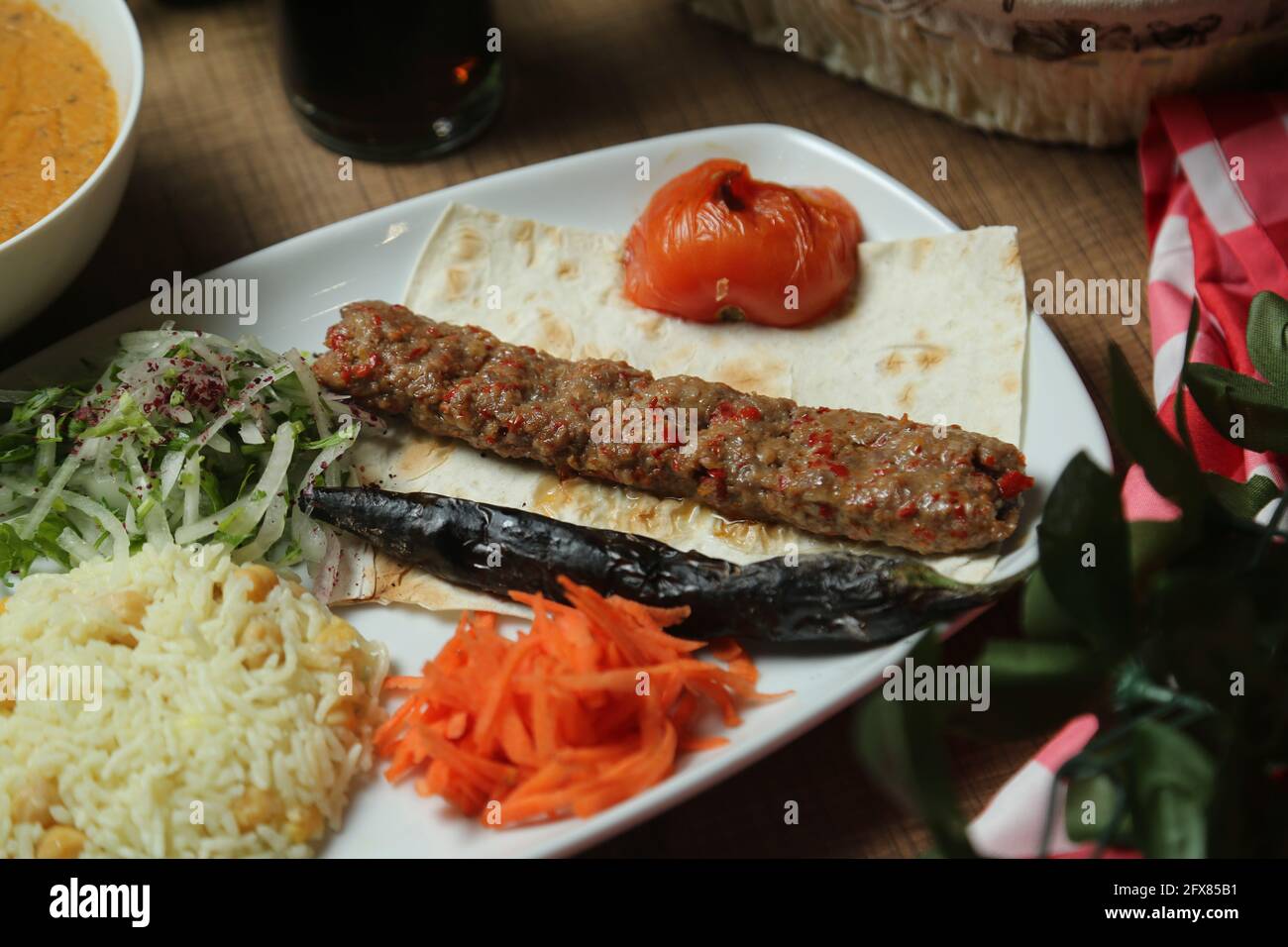 Turkish Adana Kebab with fresh vegetables on flatbread Top view, flat ...