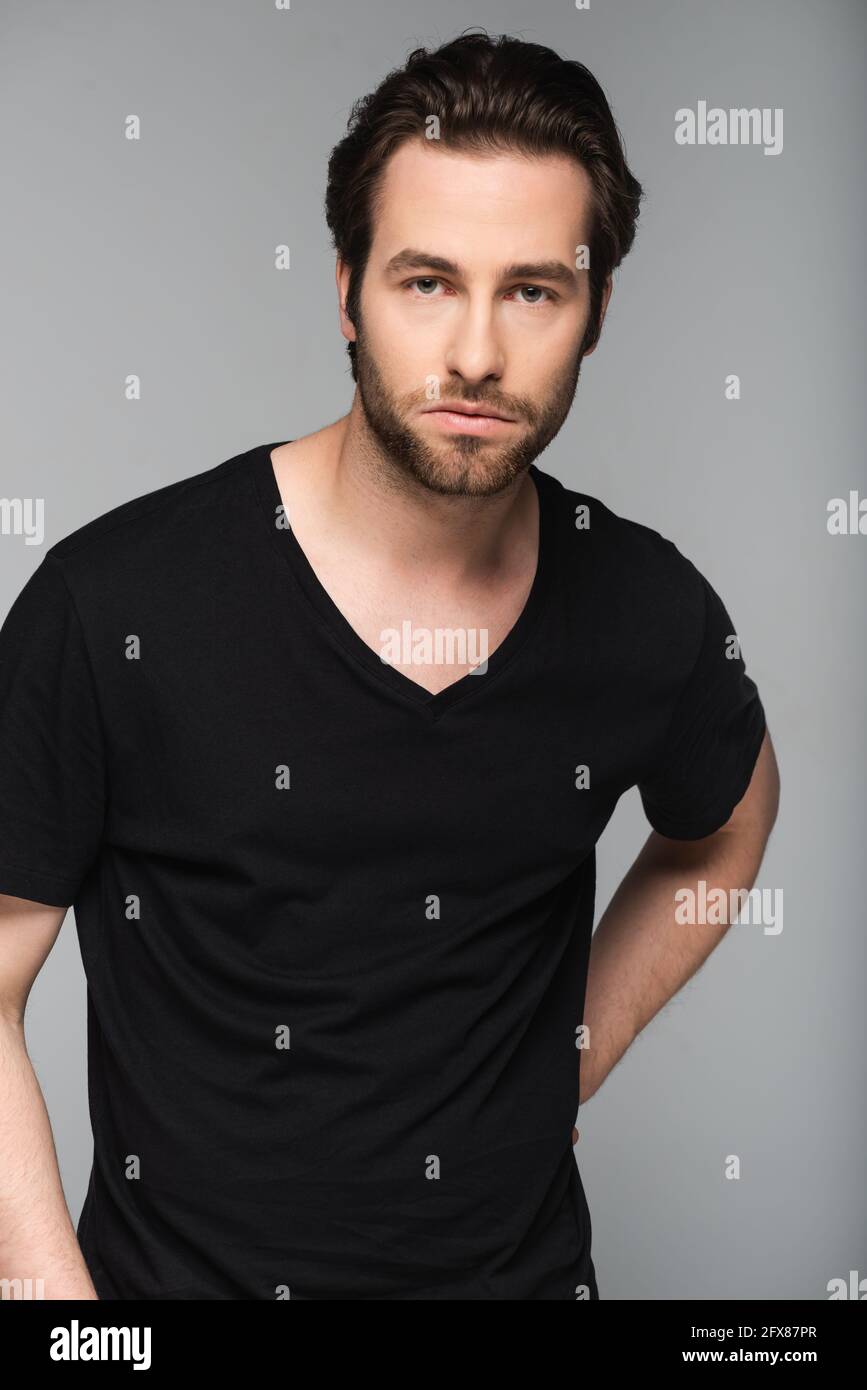 good-looking man in black t-shirt looking at camera while posing ...