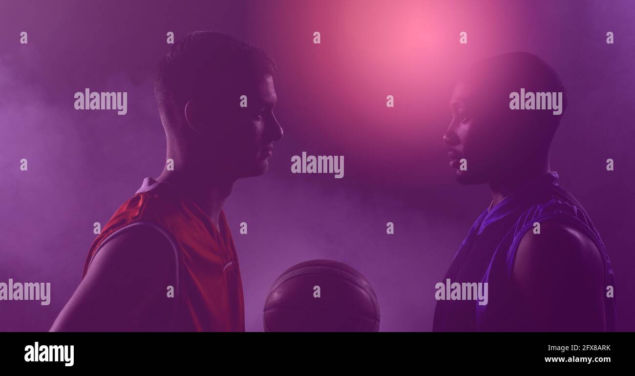 Composition of two basketball players holding ball on purple tinted ...