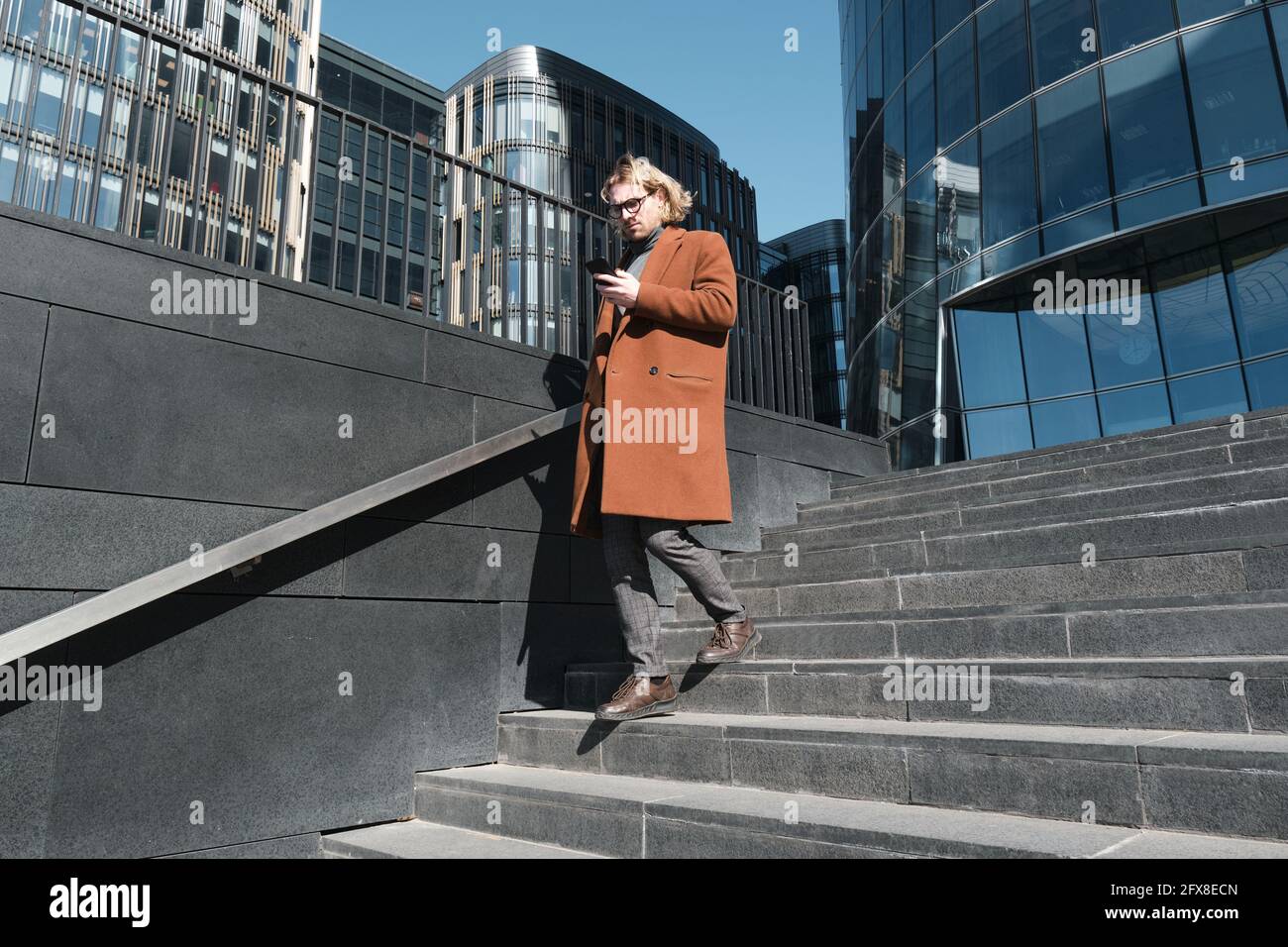 Smart man walking down steps hi-res stock photography and images - Alamy