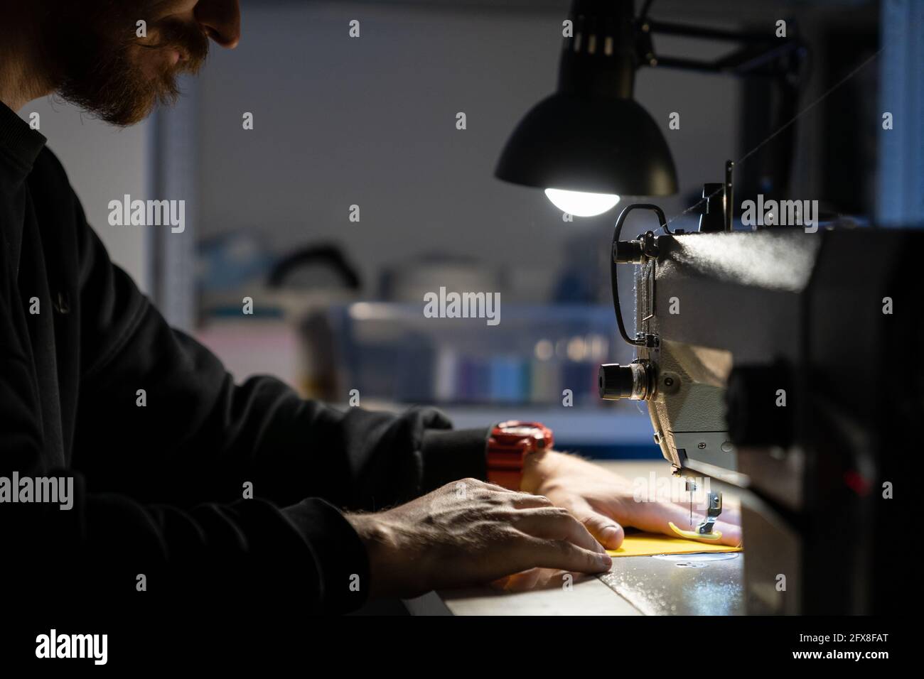 Hipster designer man sew at sewing machine. Creative work in tailoring ...