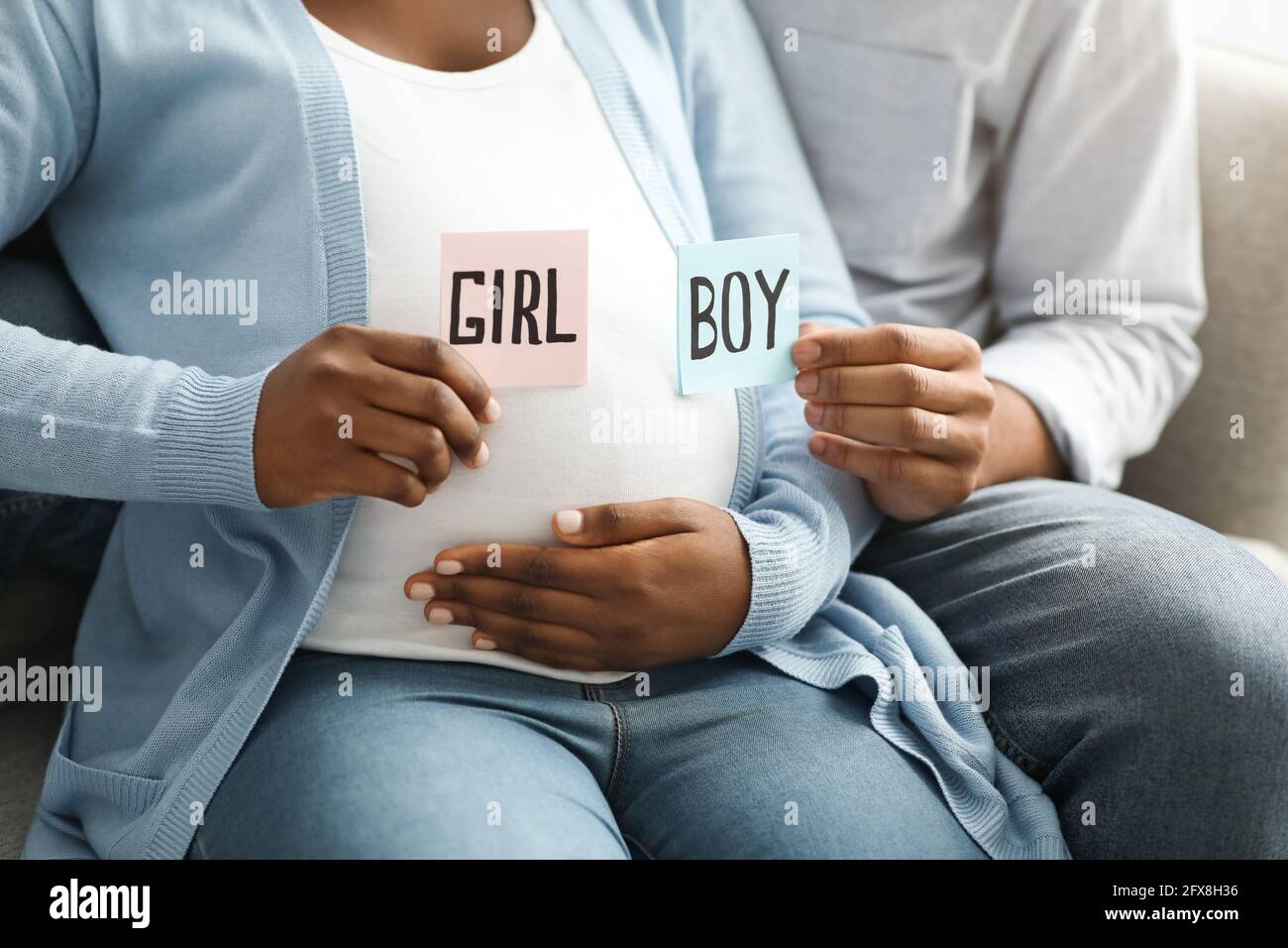 Expecting family holding color cards for baby boy or girl Stock Photo ...