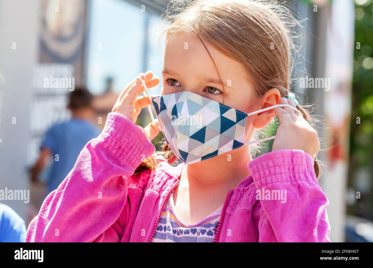 School age child, little girl taking off or putting on her colorful ...