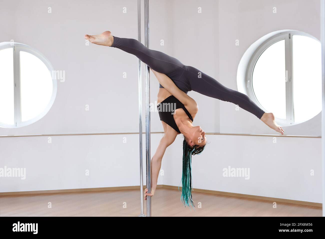 Fitness pole dancing workout routine in training studio Stock Photo - Alamy
