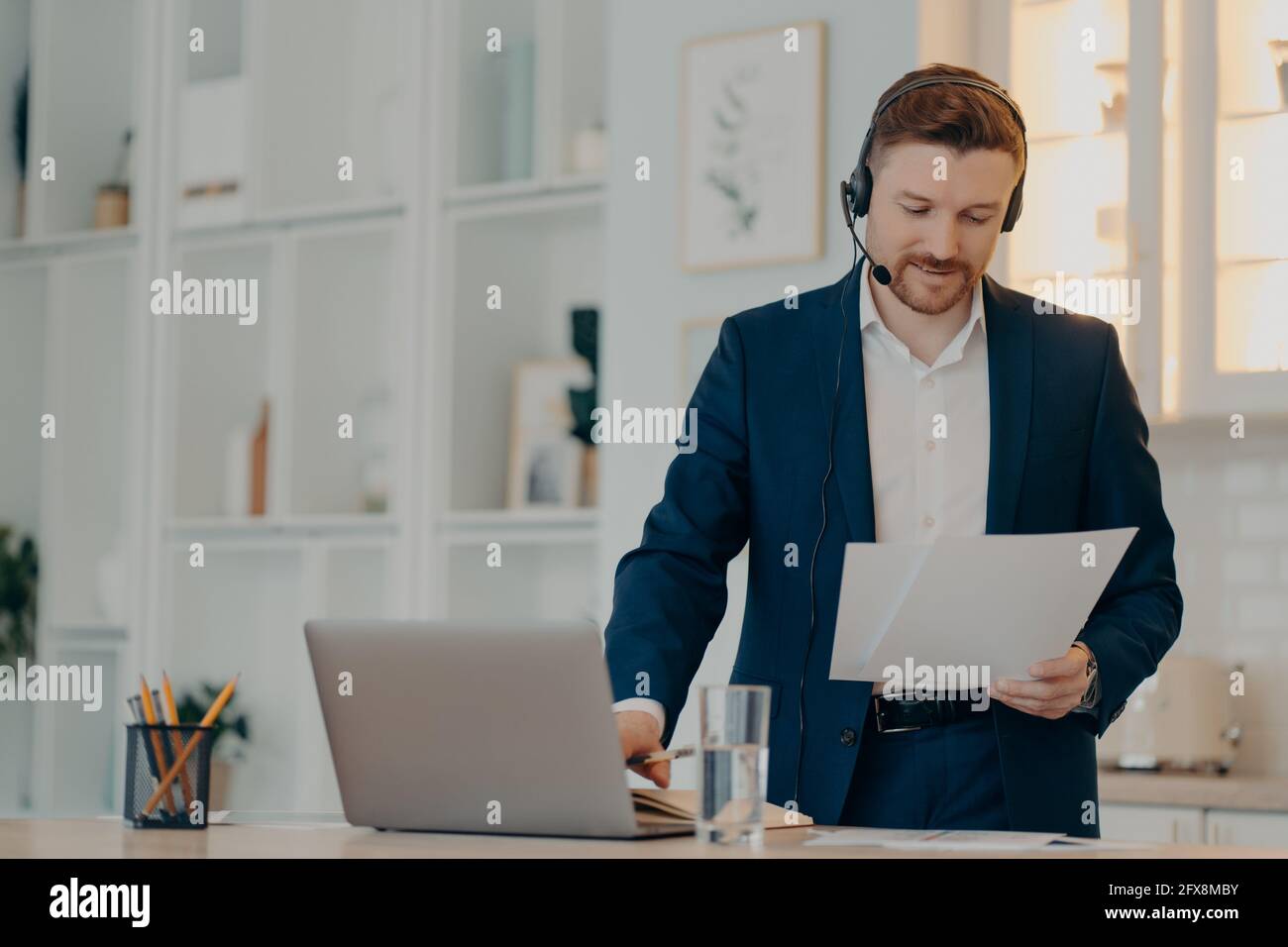 Bearded male employee chatting online and preparing report at remote ...