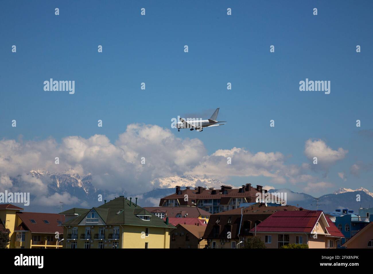 Airplane fly over buildings Plane over the roofs of houses and ...
