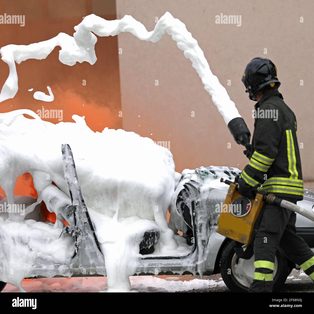 fire brigade team in action while extinguishing the fire after the car ...