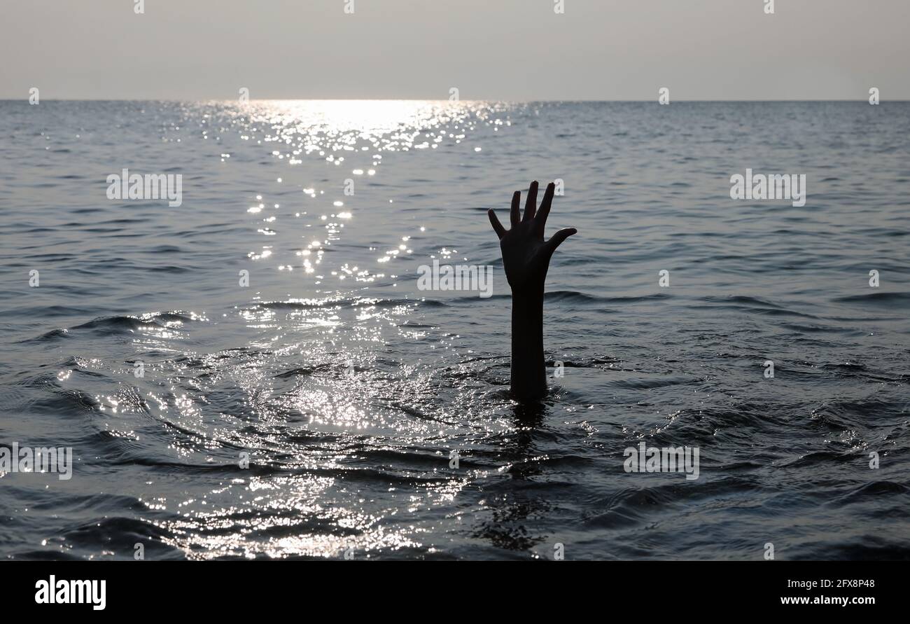 dramatic scene with the open hand of the unfortunate castaway who is ...