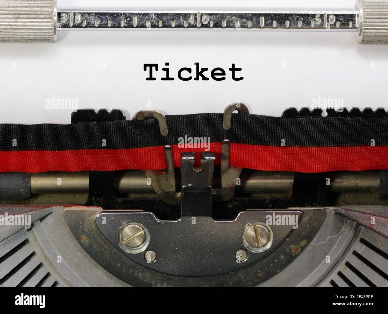 Word TICKET writen with an old typewriter on white paper with black ink ...