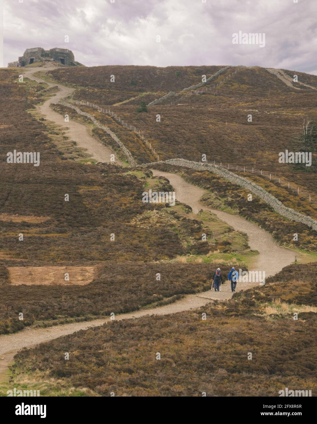 Vertical shot of people walking through a walkway on a hill under a ...