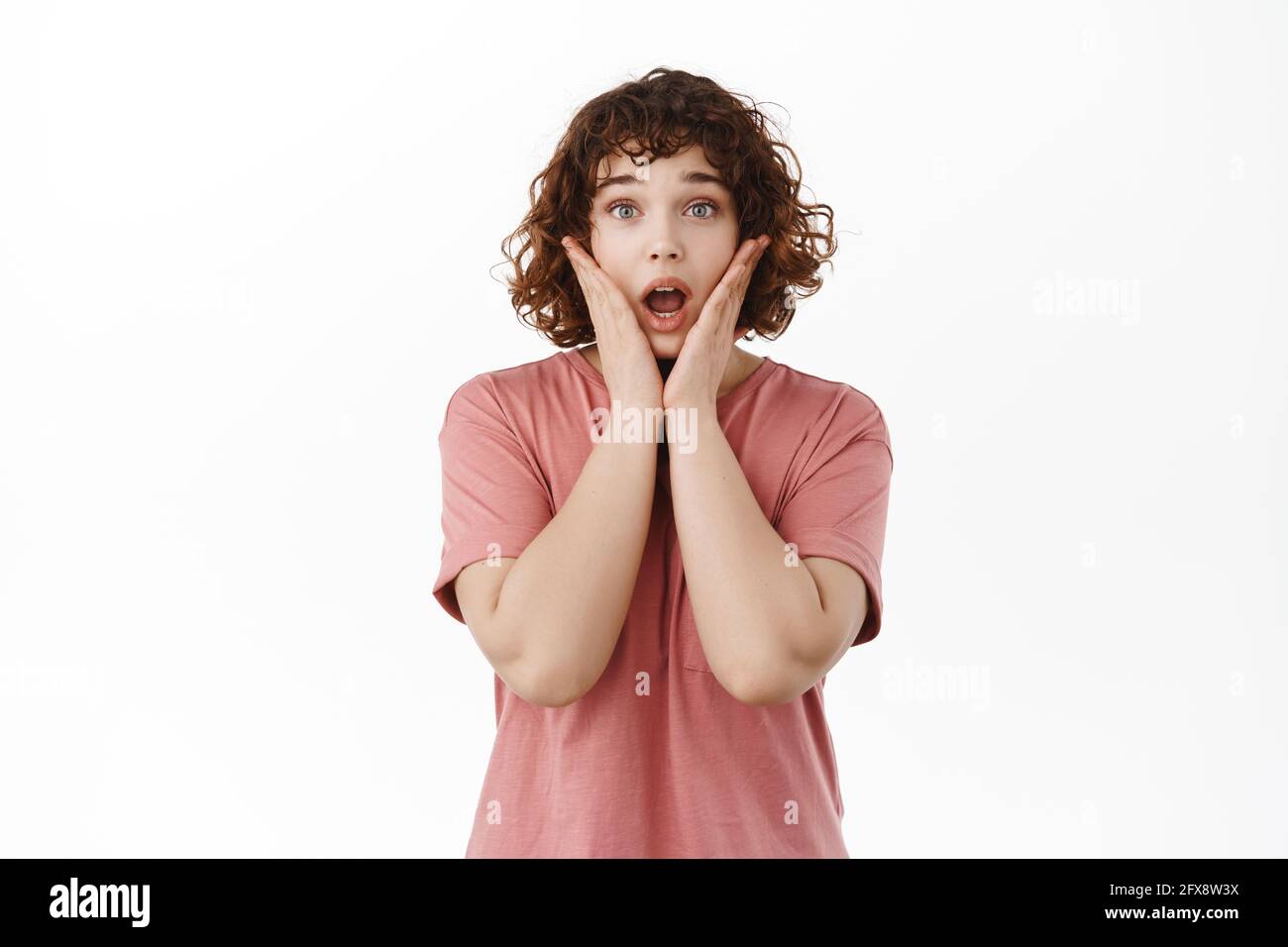 Impressed and shocked young woman, drop jaw and gasp from amazement and ...