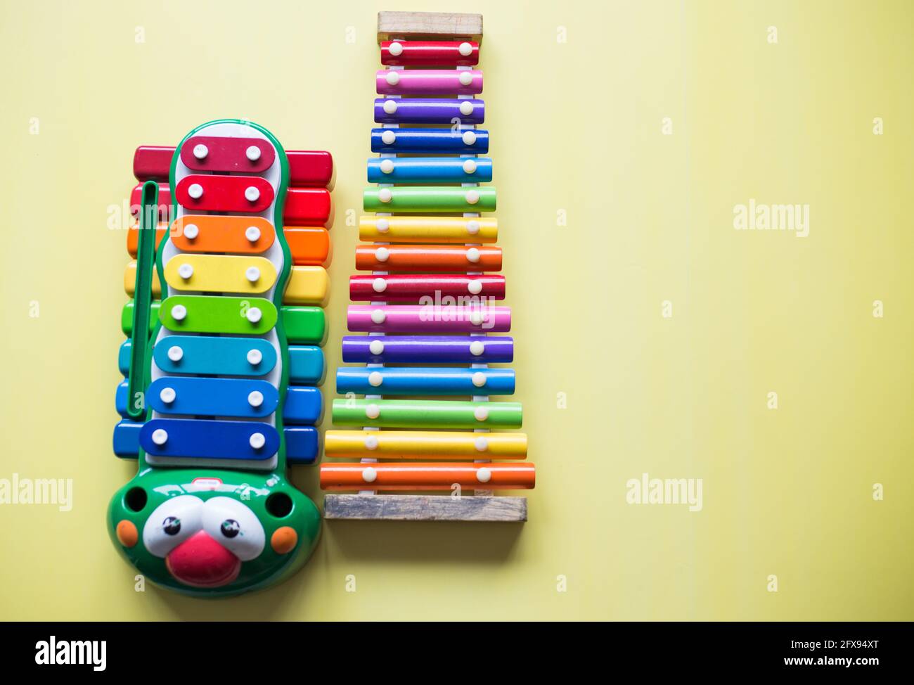 Overhead shot of toy xylophones music equipment on a yellow surface ...