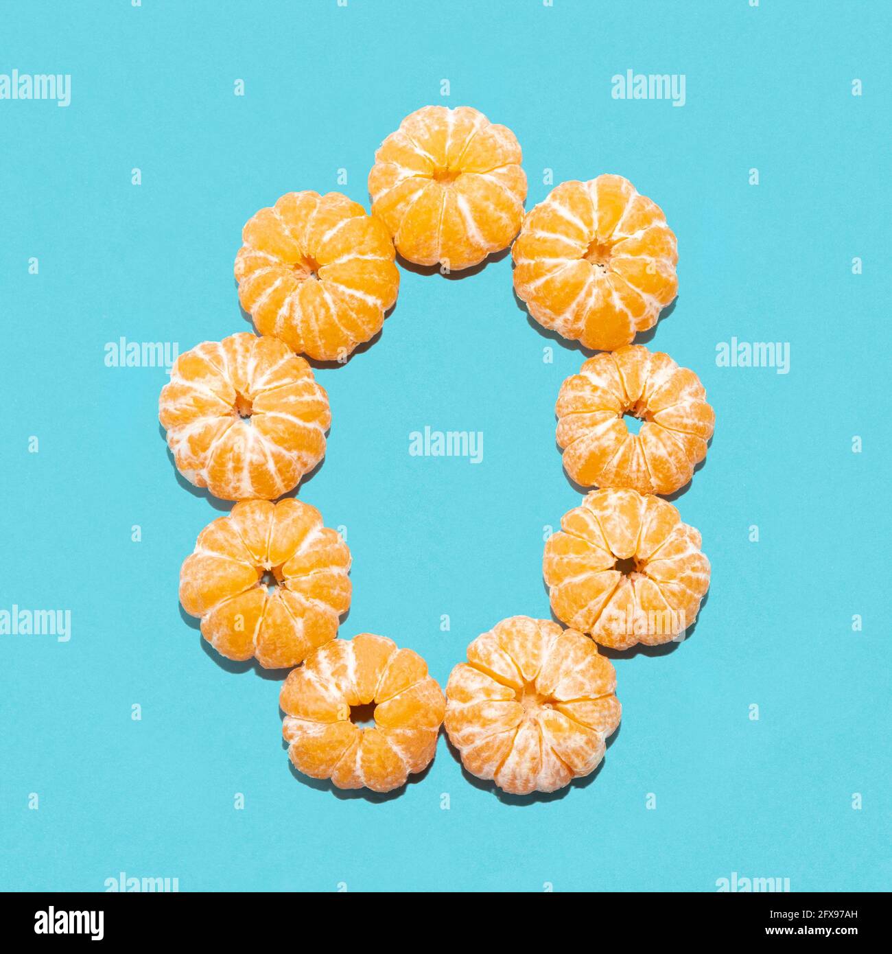 Creative layout of the letter O from peeled tangerines on a blue ...