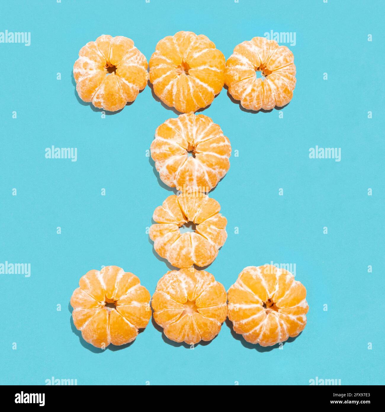 Creative layout of the letter I from peeled tangerines on a blue ...
