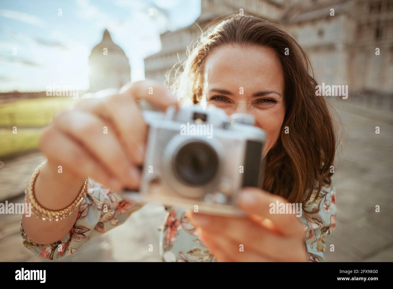 stylish solo traveller woman in floral dress with film camera near ...