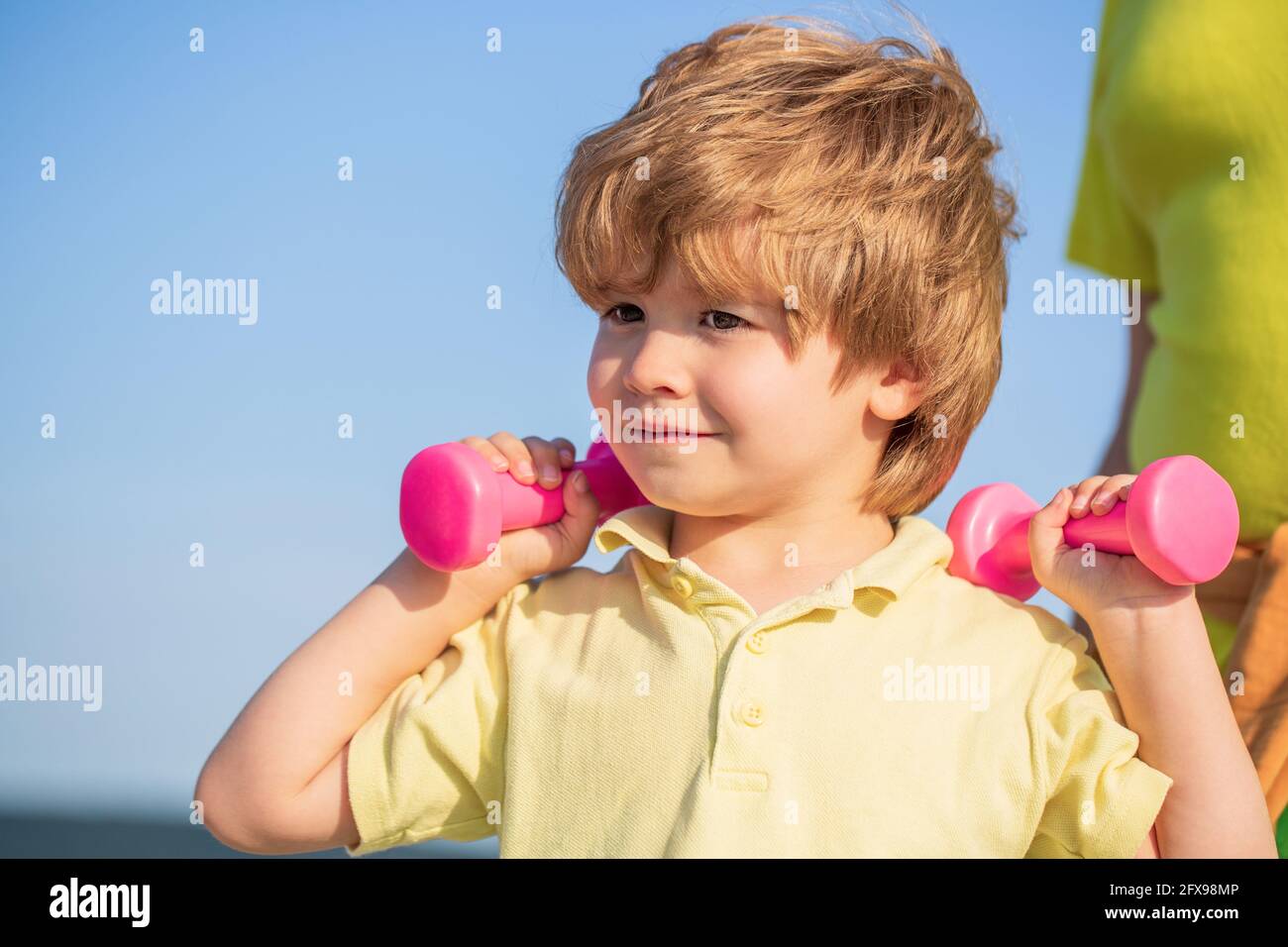 Sporty boy with dumbbells. Cheerful boy do exercises with dumbbells ...