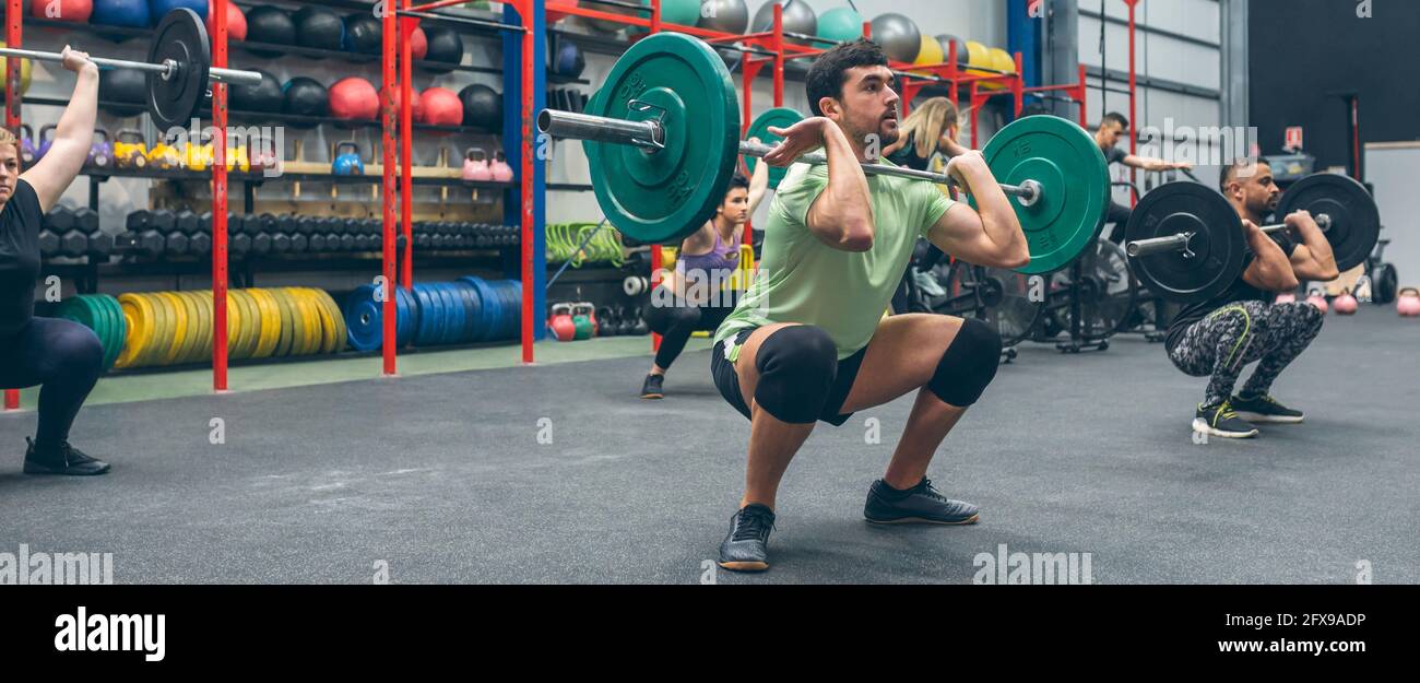 People practicing weightlifting in the gym Stock Photo - Alamy